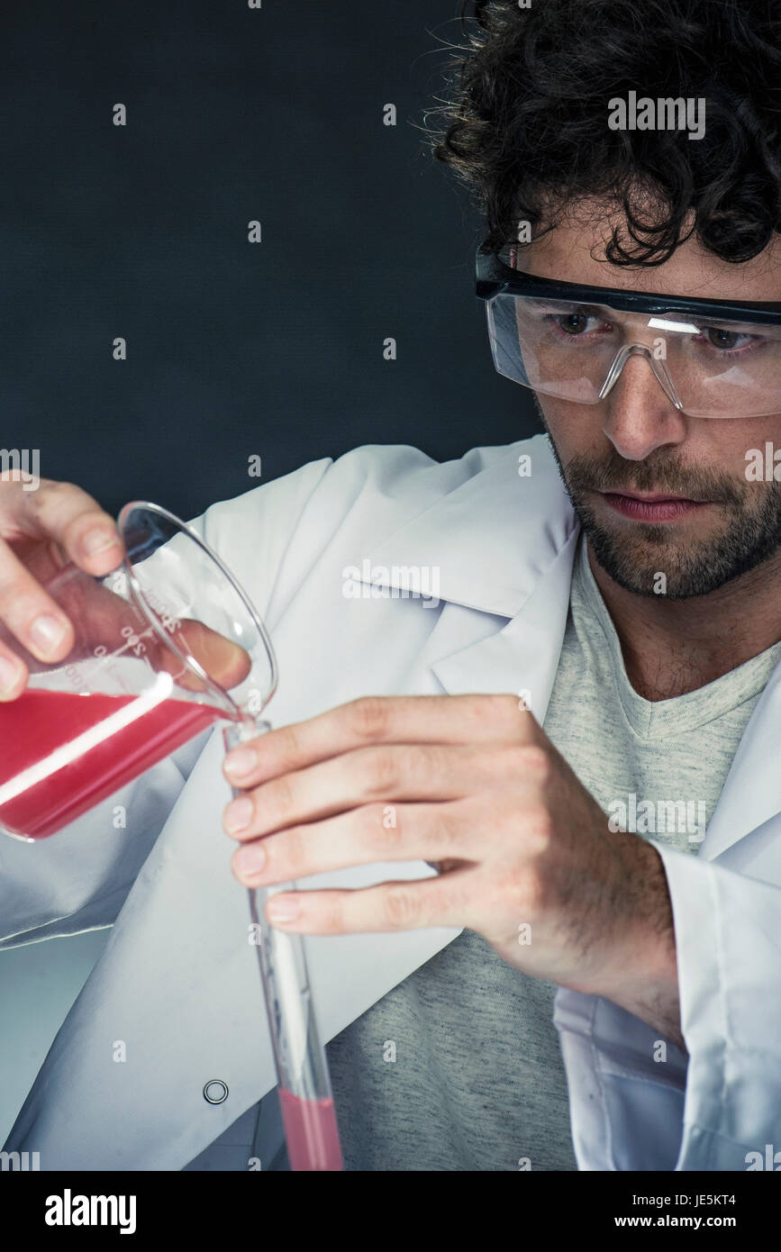 Scientist pouring liquid into test tube Stock Photo - Alamy
