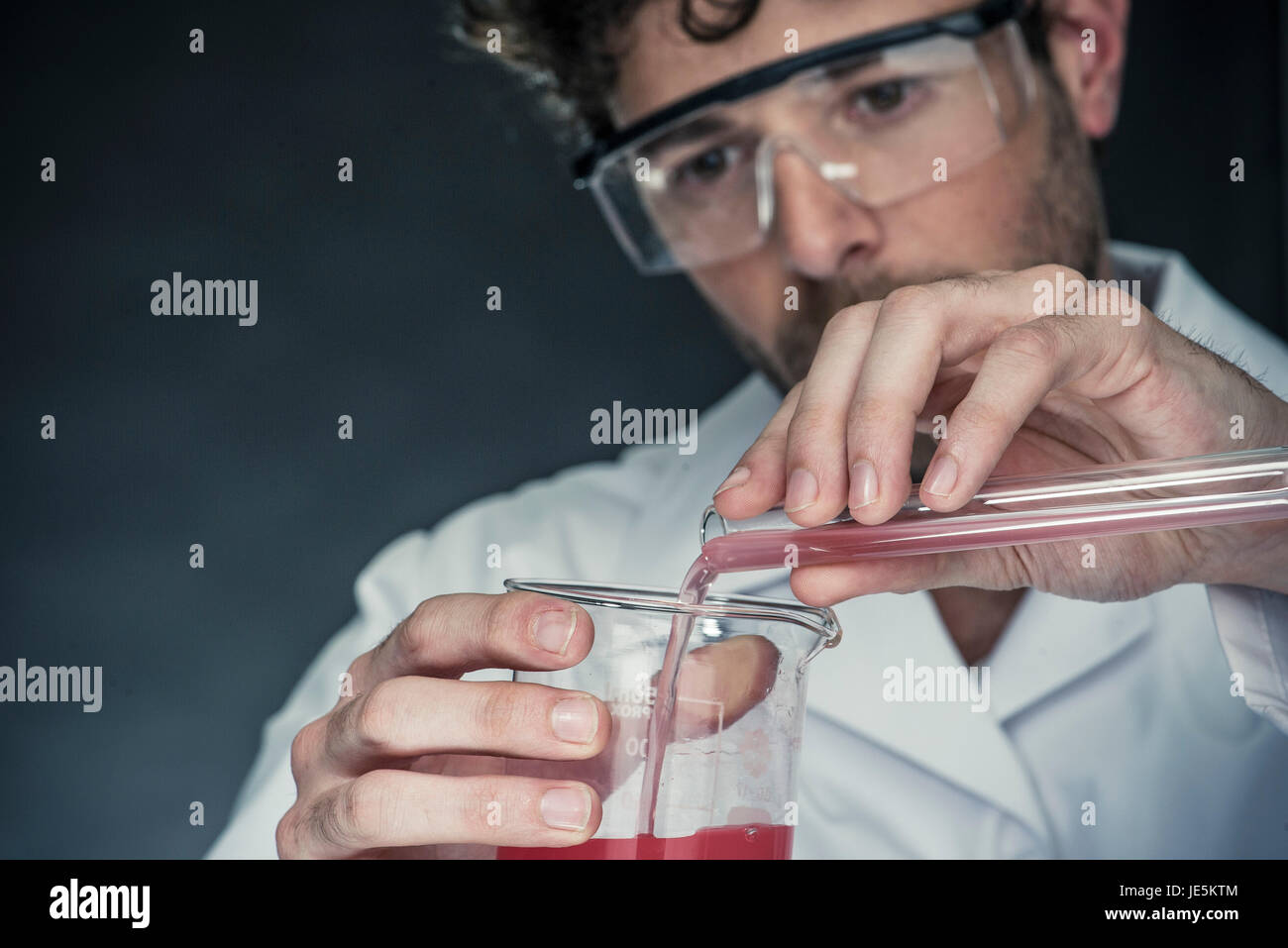 Scientist Pouring Liquid Into Beaker High Resolution Stock Photography ...