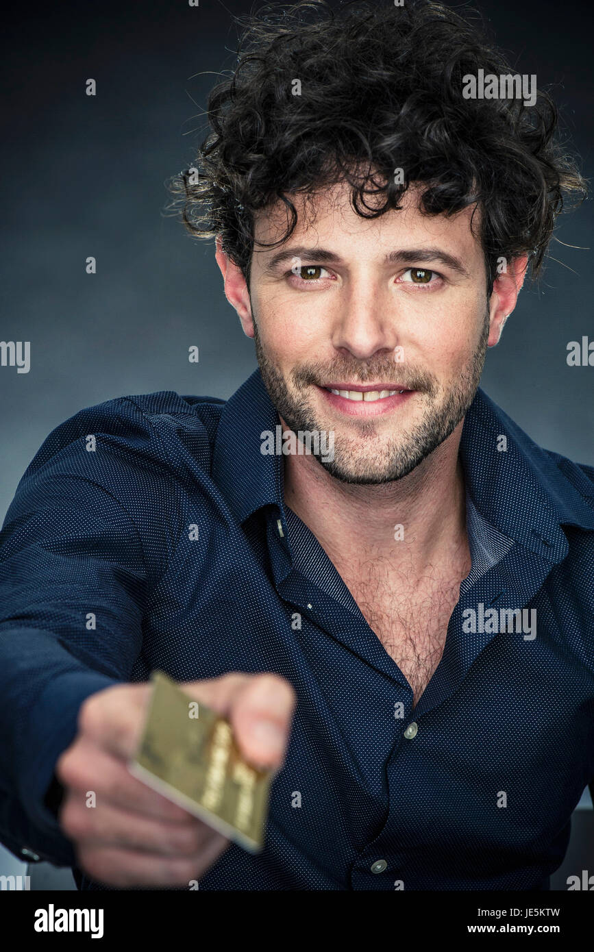 Man holding out credit card and smiling, portrait Stock Photo - Alamy