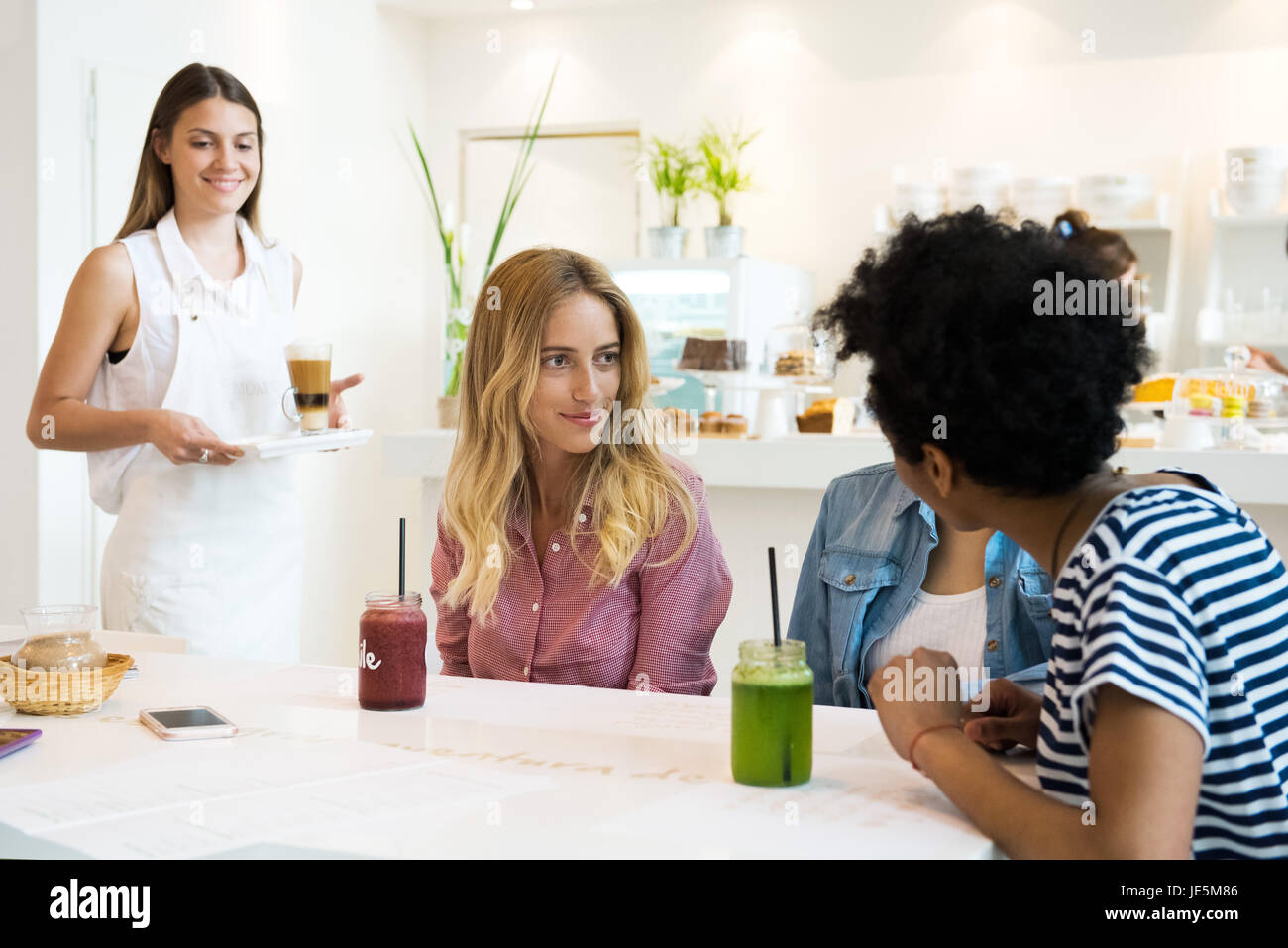 Friends chatting in cafe Stock Photo - Alamy