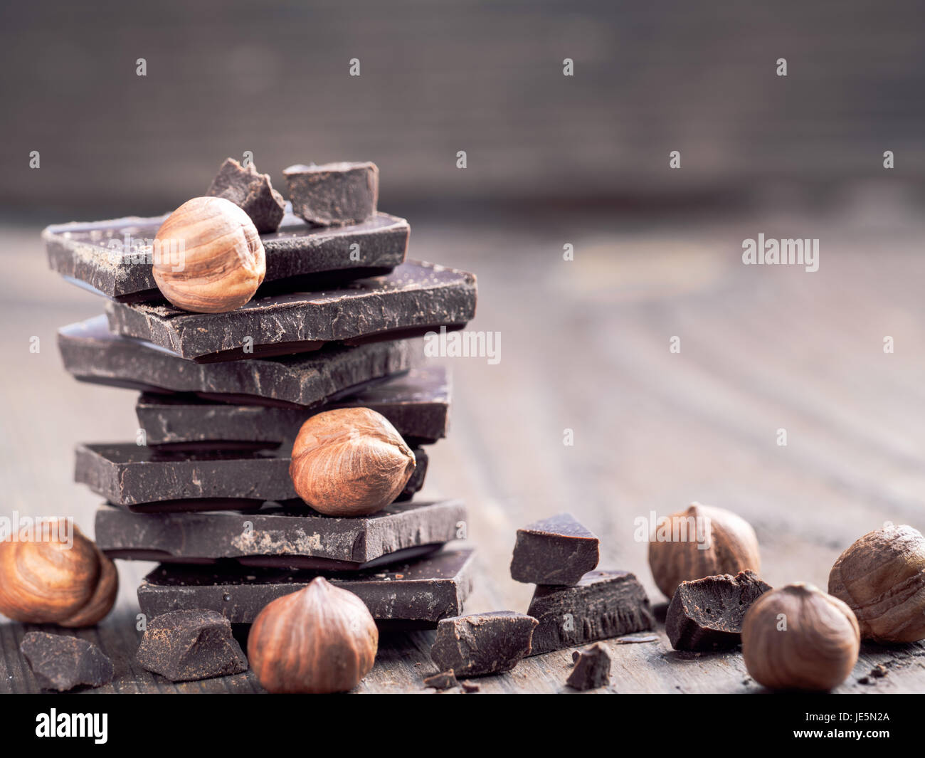Stack of dark chocolate and whole hazelnut with copy space. Chocolate ...