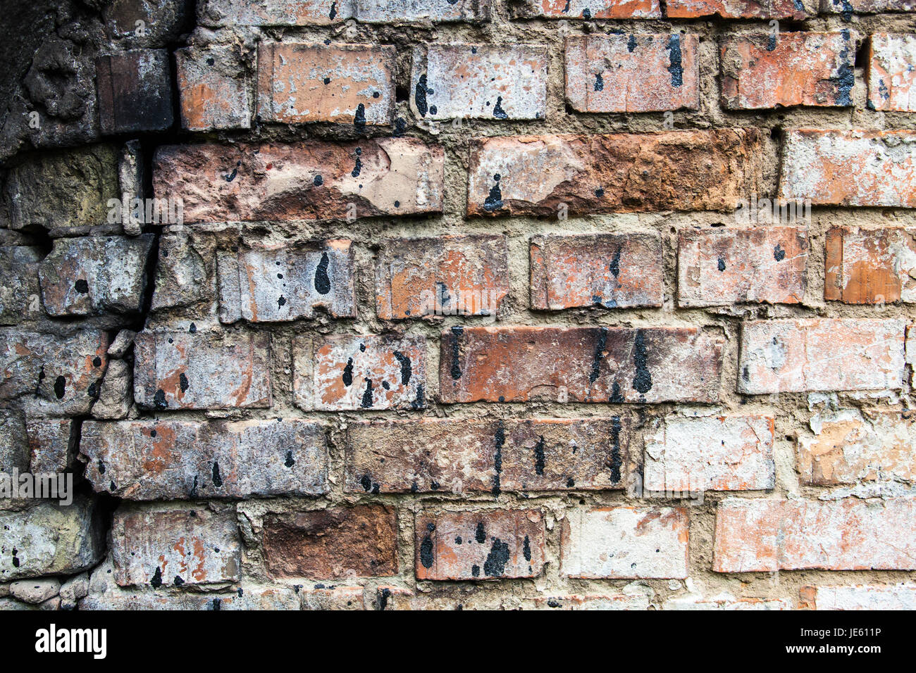 The old cracked brick wall stained with black tar Stock Photo - Alamy