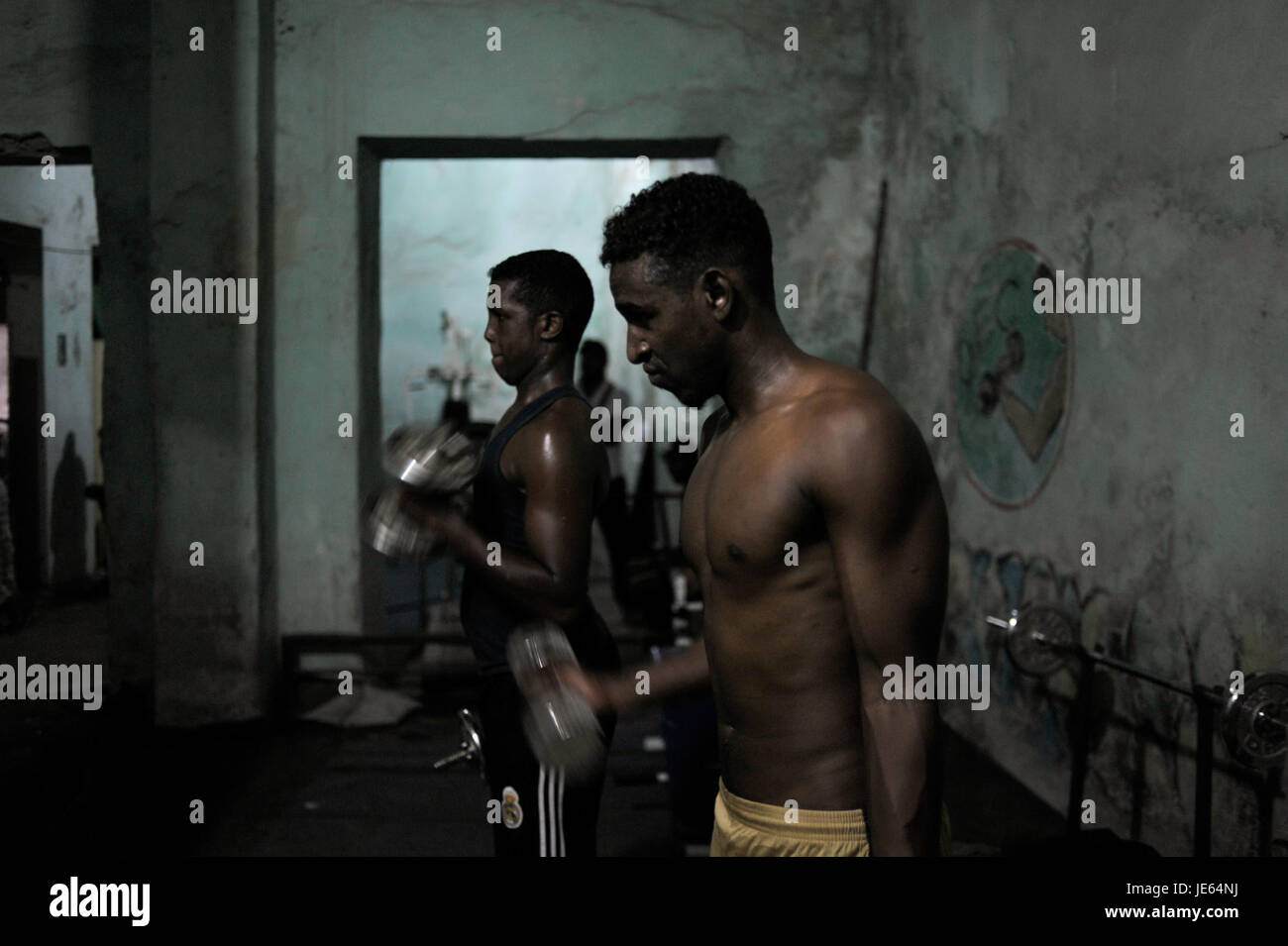 This image depicts weightlifters in action during a training session in ...