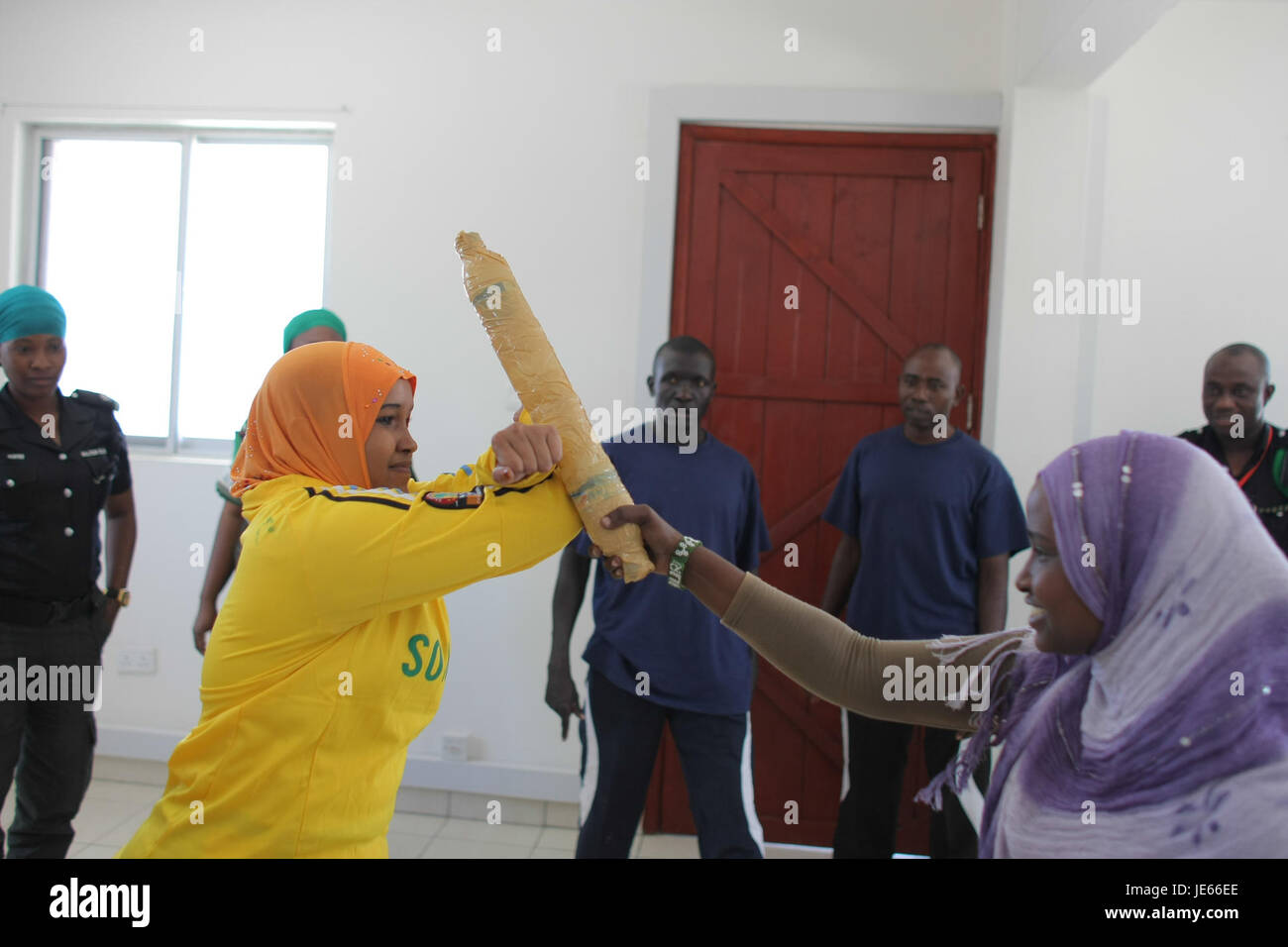 The image shows women participating in self-defense training, aimed at ...