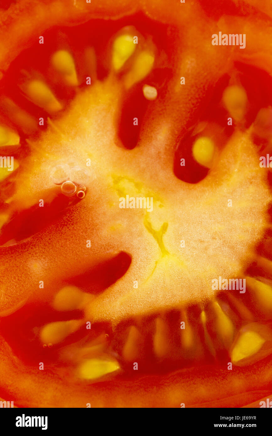 Vertical close up of sliced red tomato reveals interior with seeds and ...