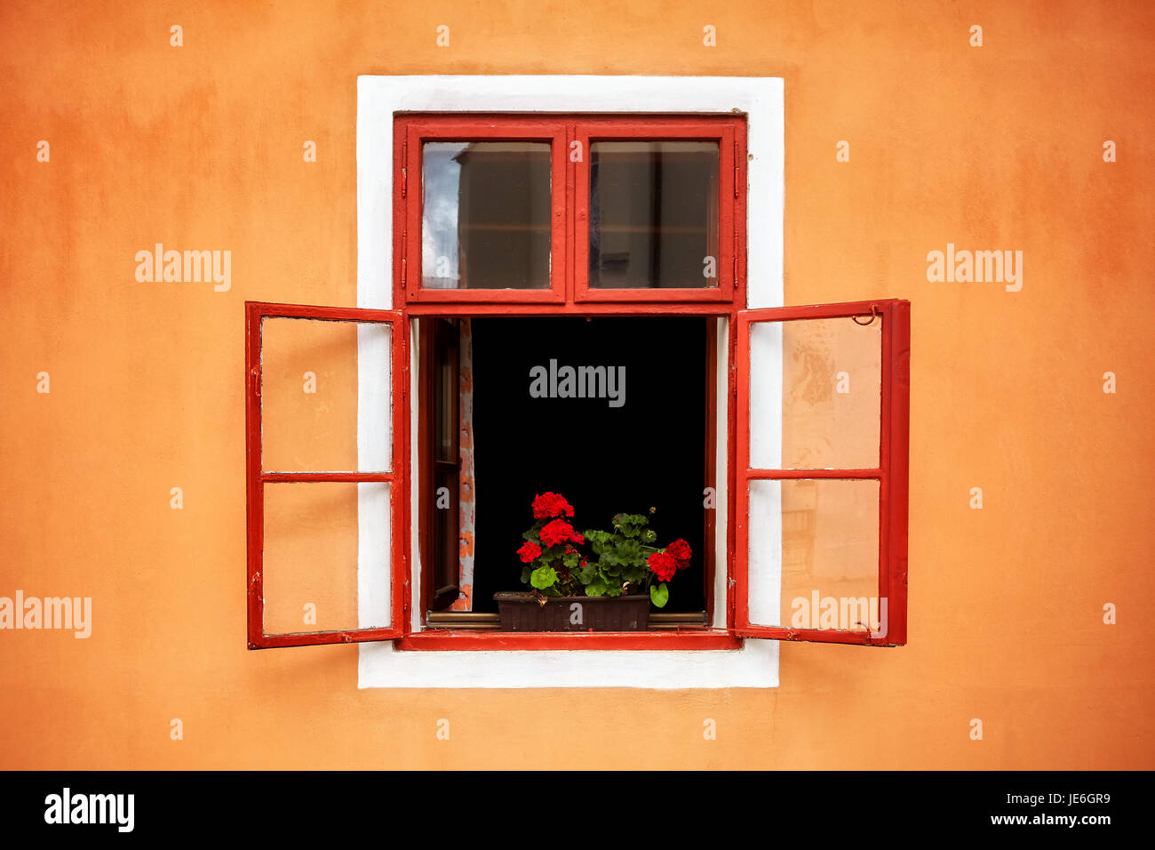 Opened old red window with flowers in orange wall Stock Photo - Alamy