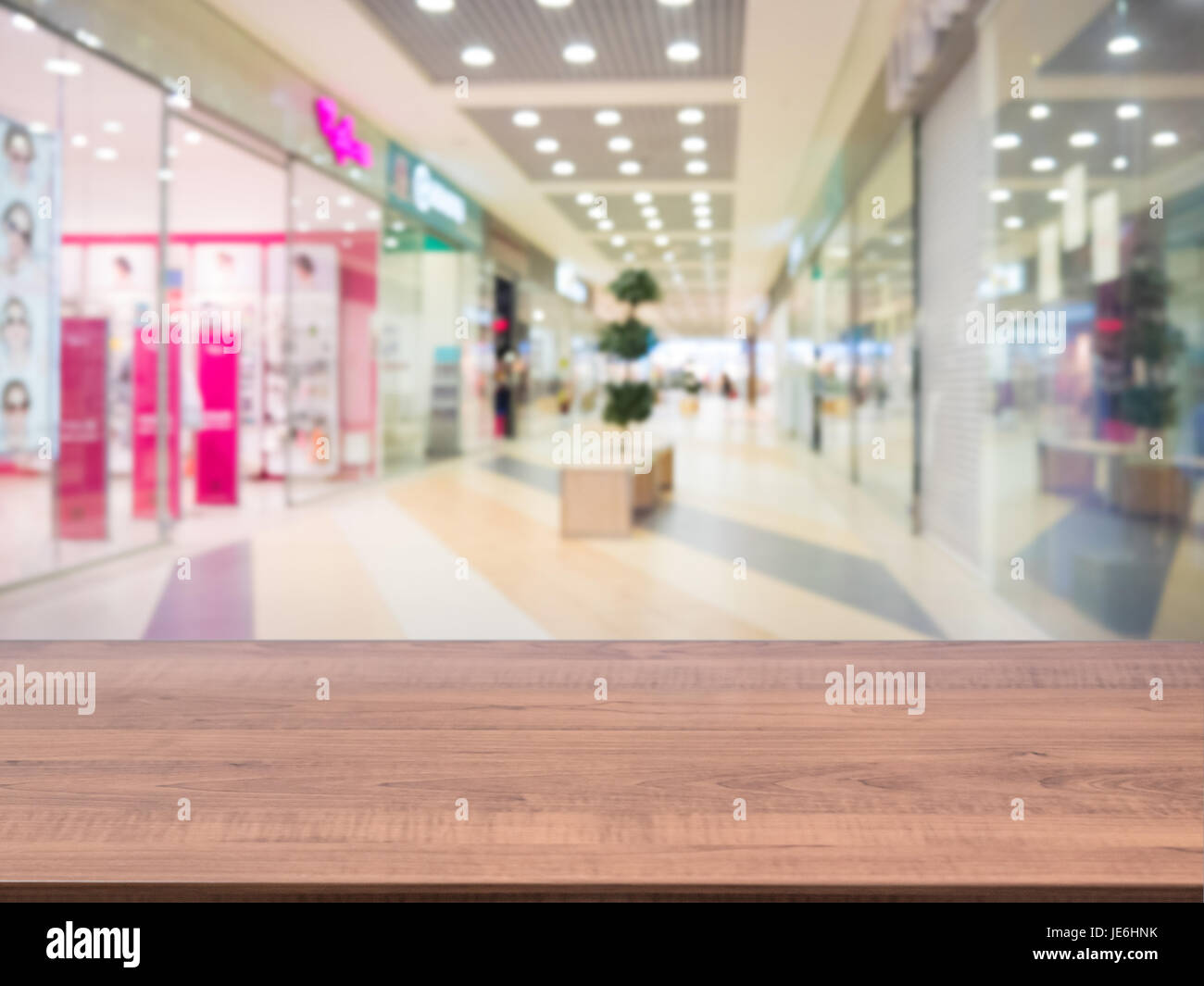 Brown wooden board empty table in front of blurred shopping mall - can ...