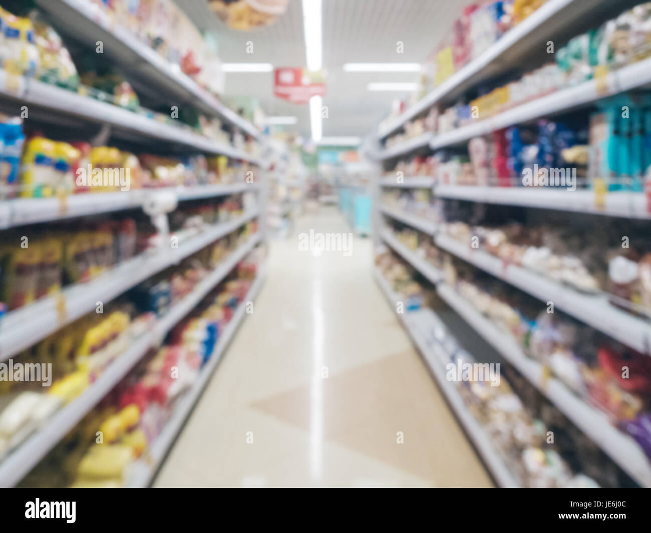 Abstract blurred supermarket aisle with colorful shelves and ...