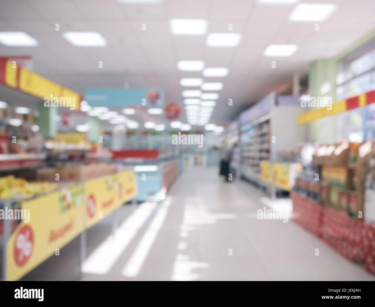 Abstract blurred supermarket aisle with colorful shelves and ...