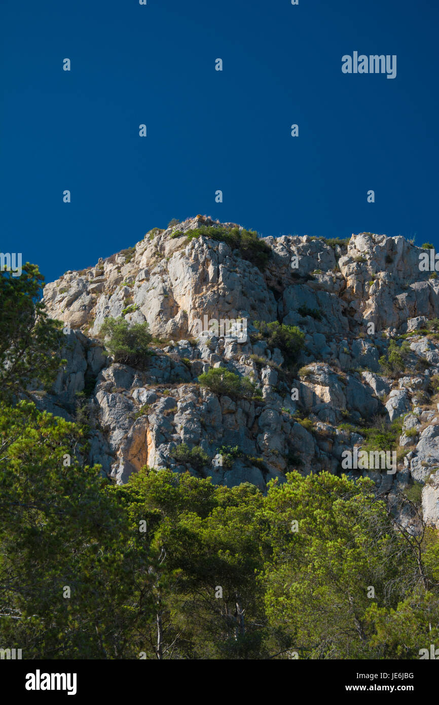 Rock formation and pine trees above the town of Estartit on the Costa ...