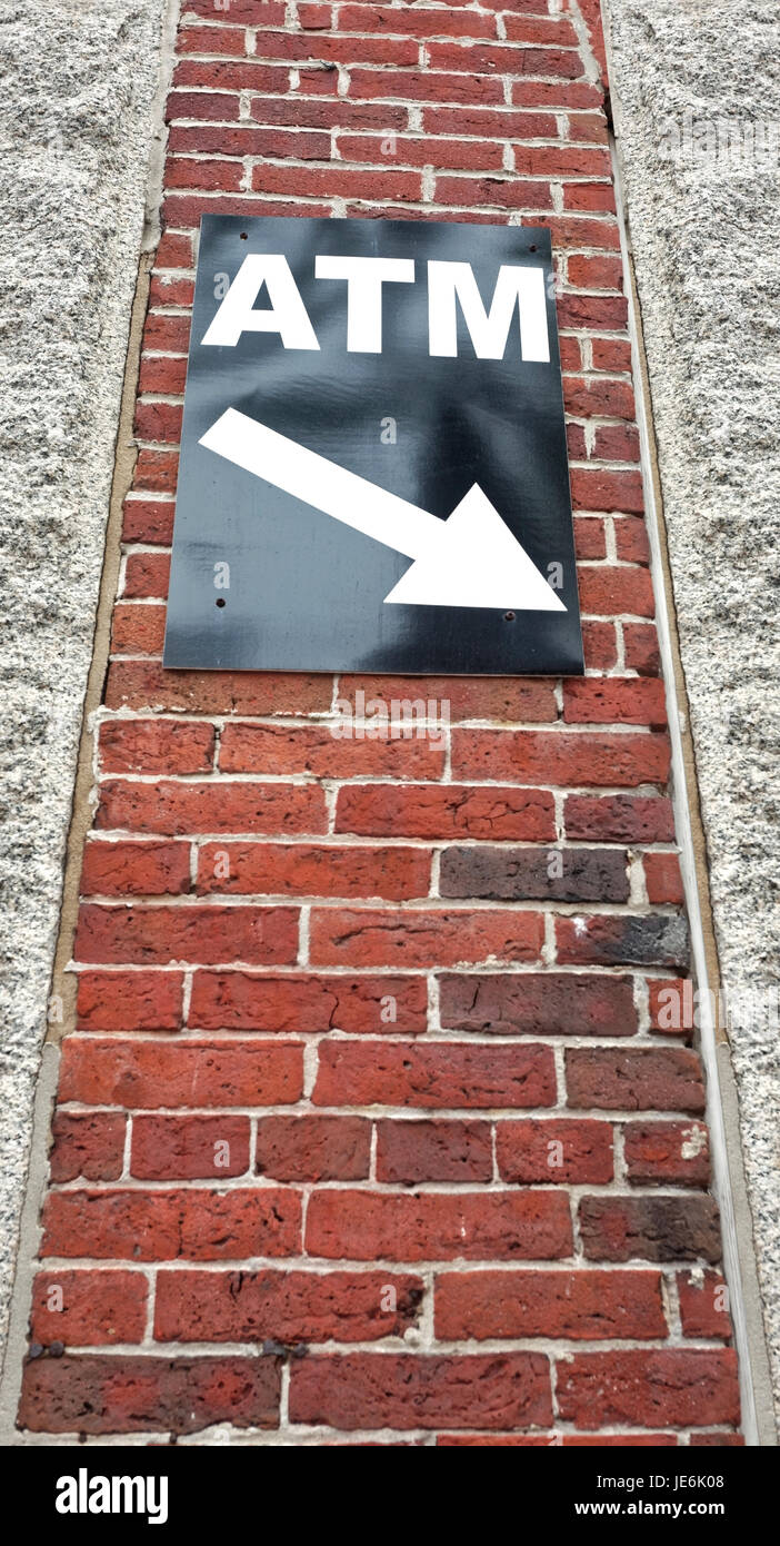 ATM sign attached to brick wall pointing down. Vertical Stock Photo - Alamy