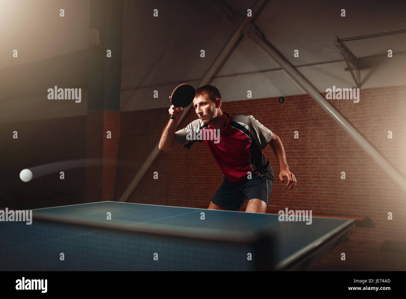 Table tennis, male player with racket in action, ball with trace. Ping ...