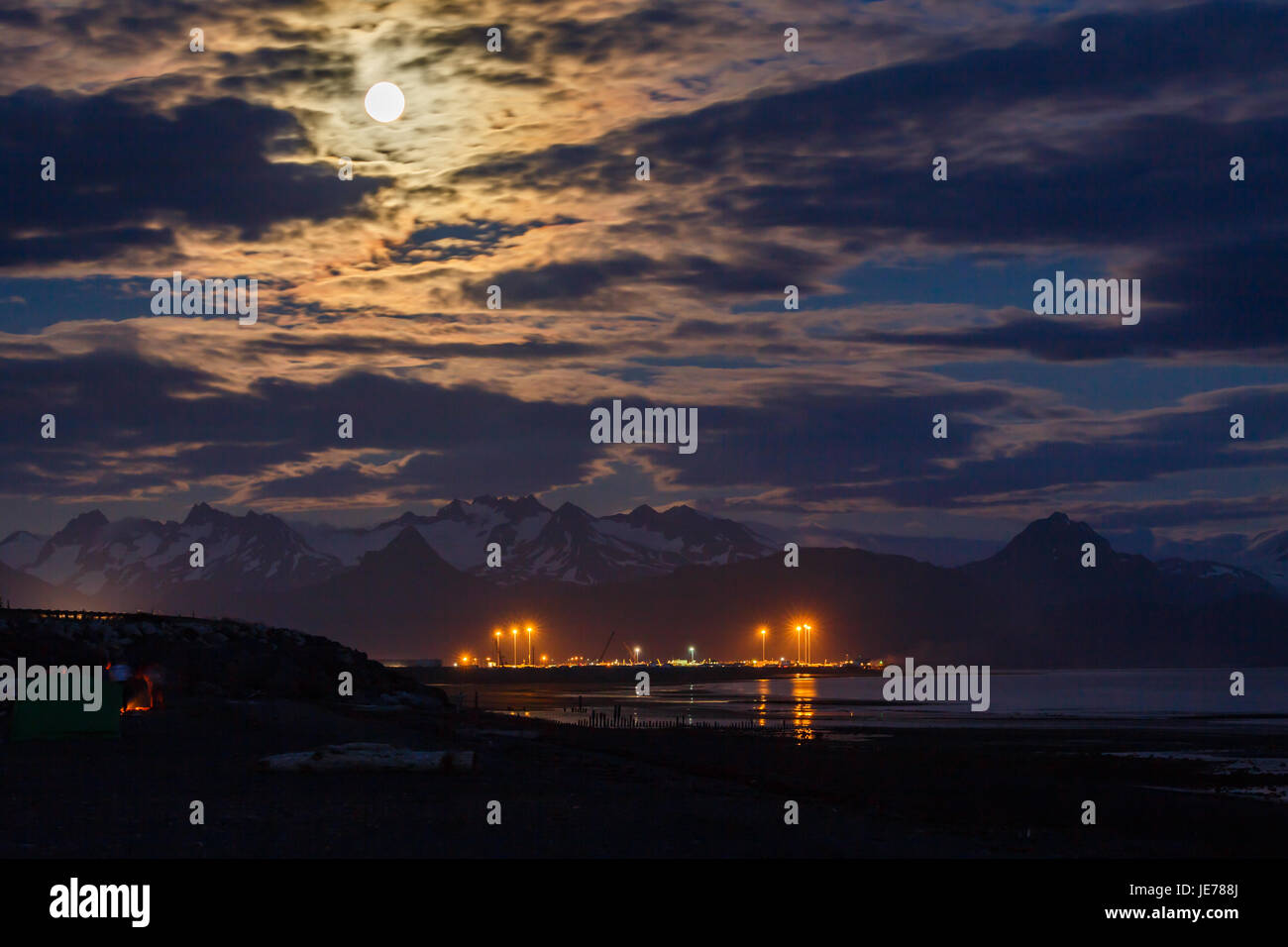 Nightime lights of Home spit harbour at night with full moon and ...
