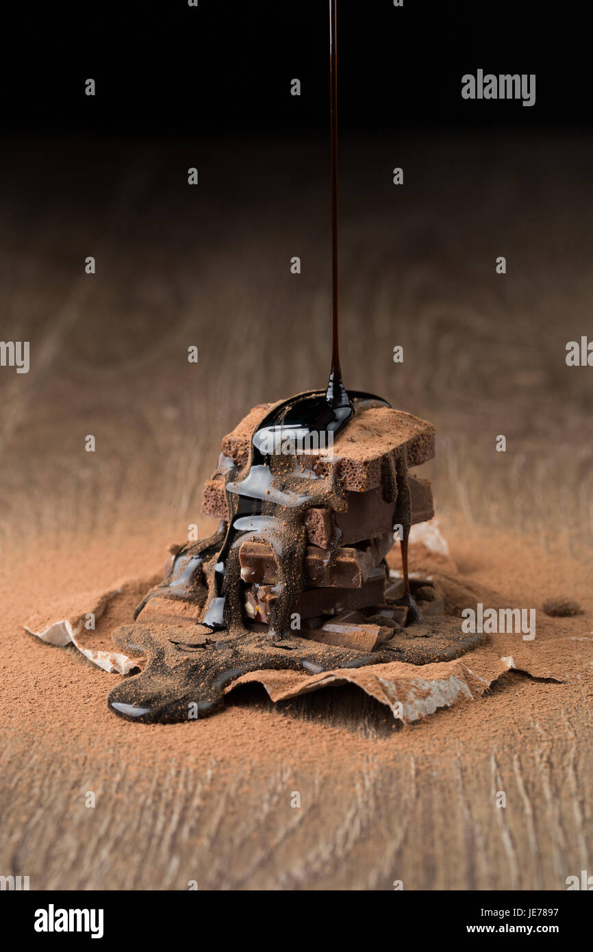 Chocolate pyramid with syrup, cocoa powder on wooden table Stock Photo ...