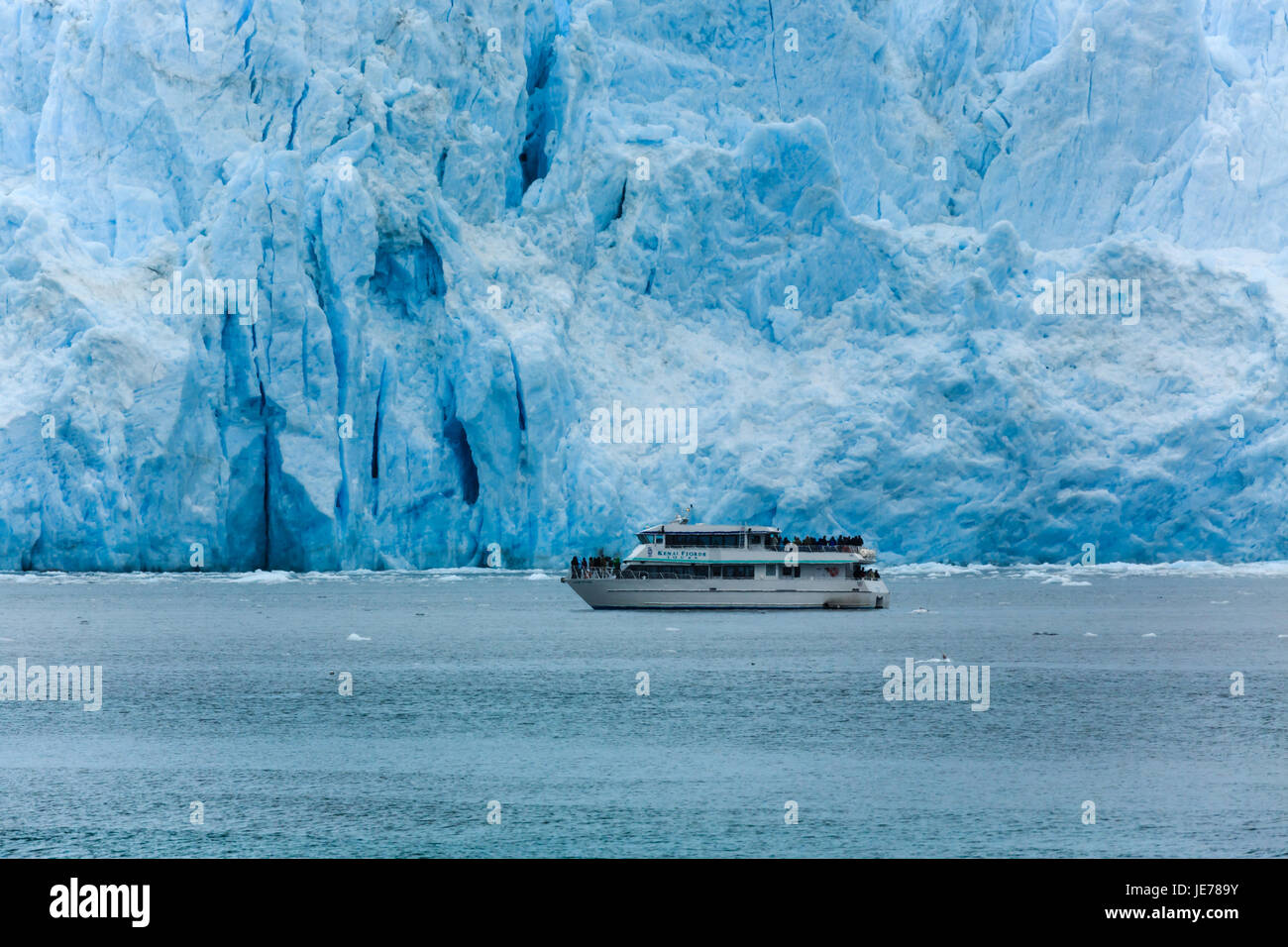 Boat traveling past large glacier shows how large the ice formation is ...