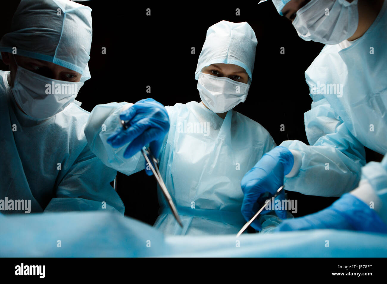 Photo of doctors with surgical instruments in operating room, black ...