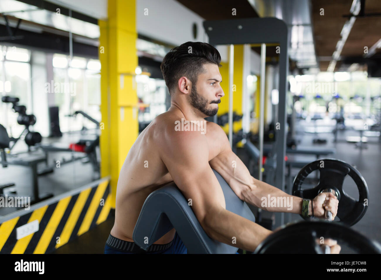 Athlete muscular bodybuilder in gym training biceps Stock Photo - Alamy