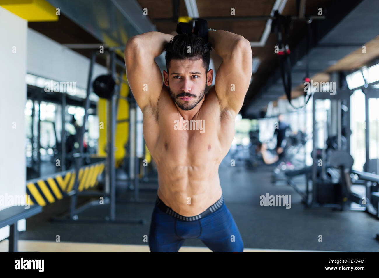 Young man doing trx exercise in gym Stock Photo - Alamy