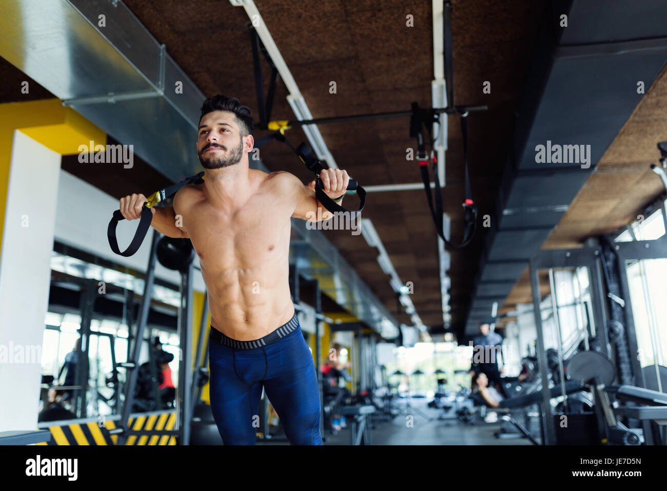 Young man doing trx exercise in gym Stock Photo - Alamy