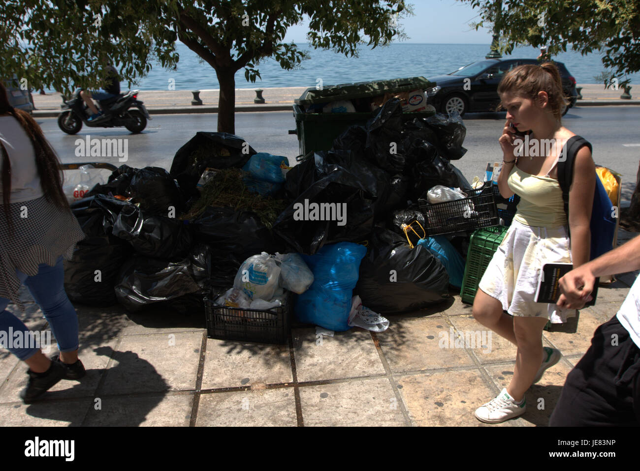 Thessaloniki, Greece, 23rd June, 2017. People walks pass piles of ...