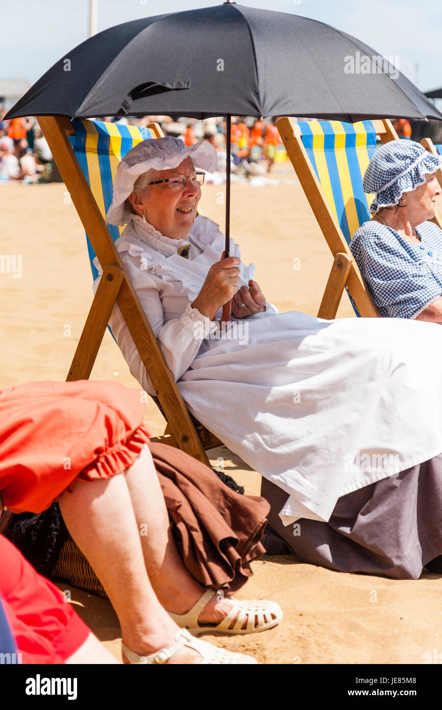 Senior woman, 60s, sitting in a deckchair, on the sands at Broadstairs ...