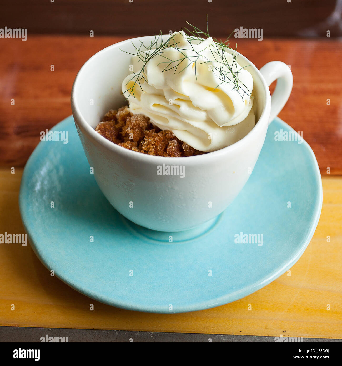 Coffee granite with white chocolate foam and wild fennel, in a blue cup ...