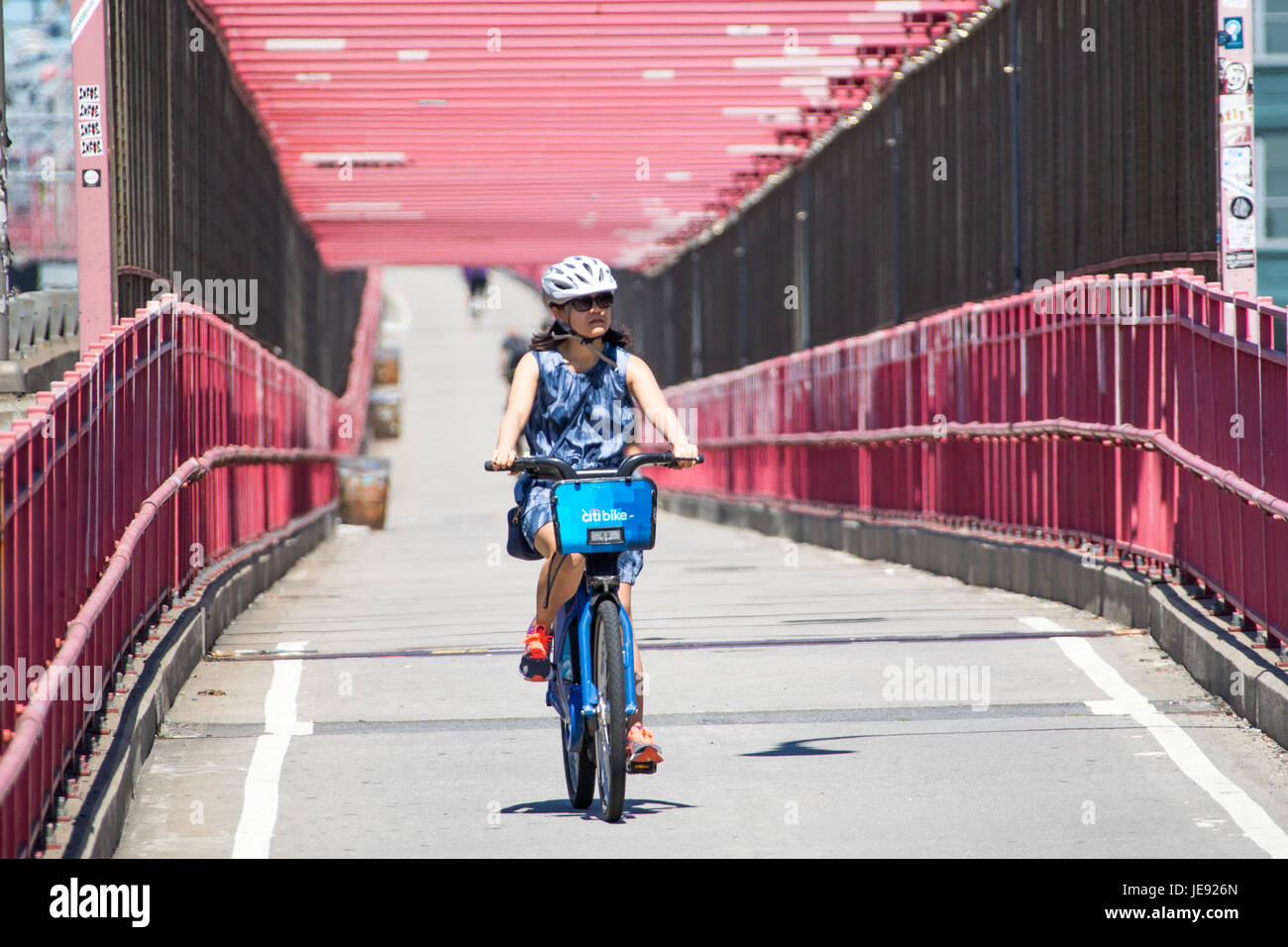 Asian tourist riding a CitiBike bike share on the Williamsburg Bridge ...