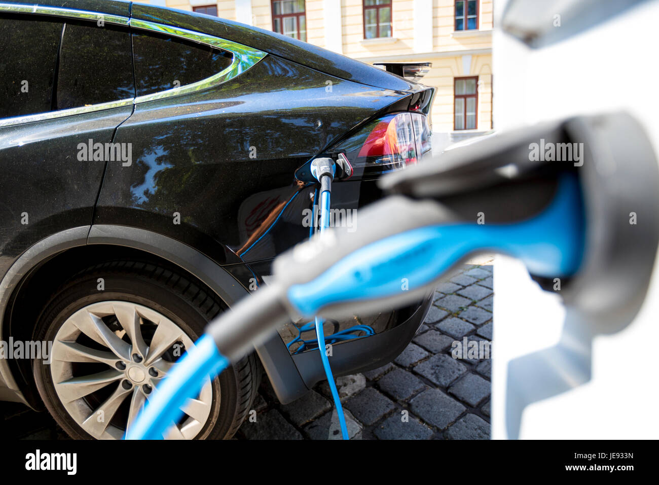 Close up of the power supply plugged into an electric car being charged ...