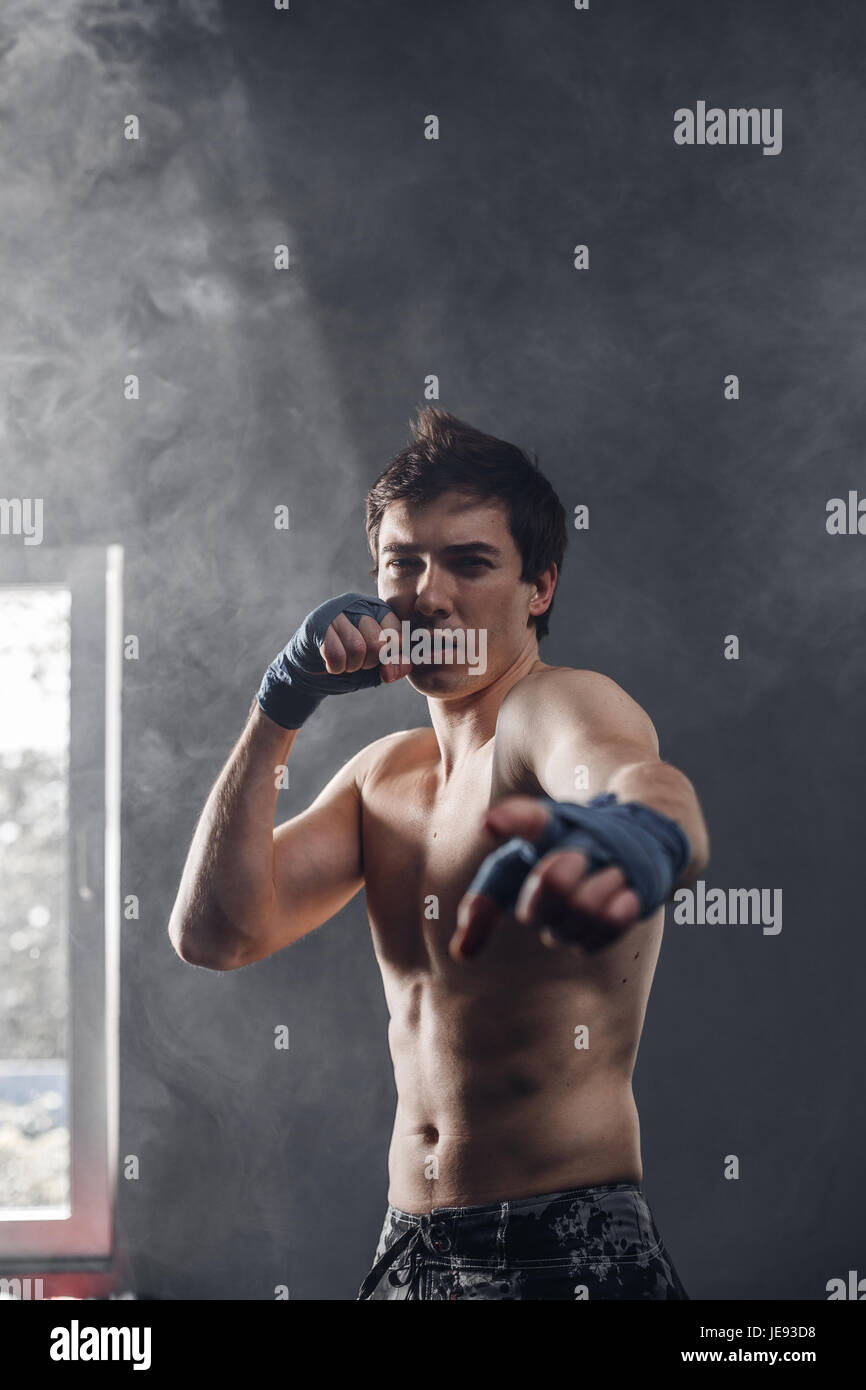 Boxer in the sun and smoke training hands with boxing wraps Stock Photo ...