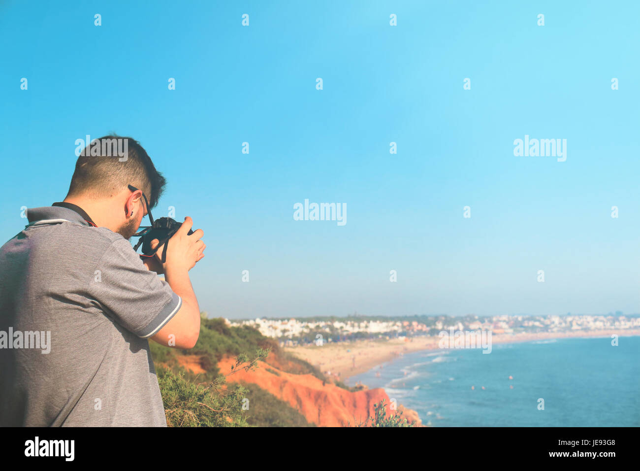 Young photographer making photos of a seascape with his camera Stock ...