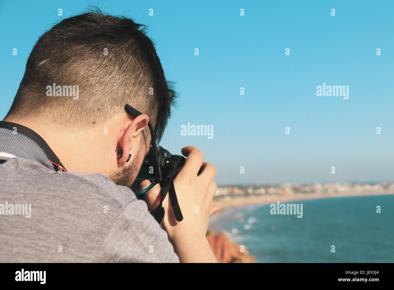 Young photographer making photos of a seascape with his camera Stock ...