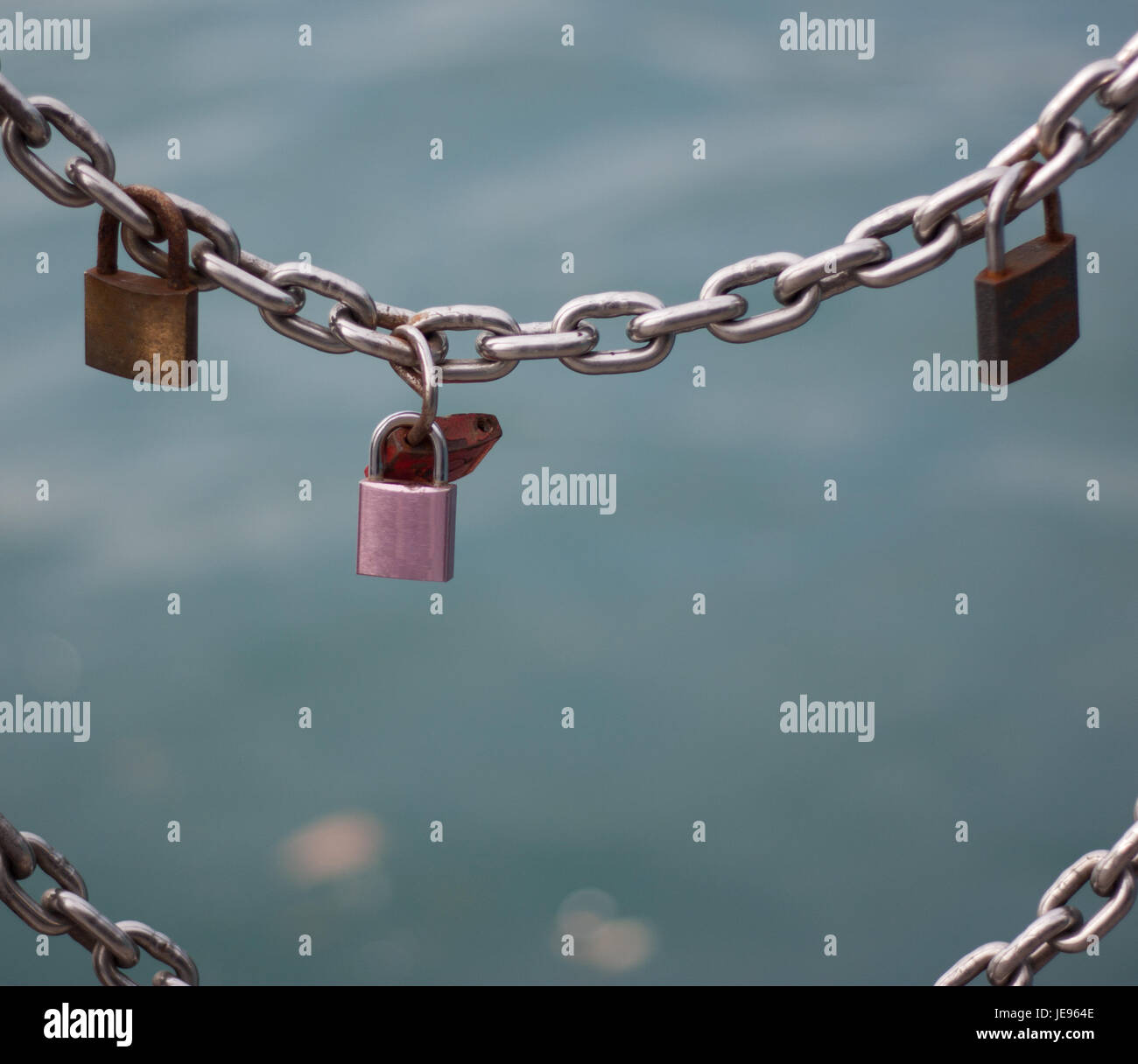 Four rusty locks connected to a chain Stock Photo - Alamy