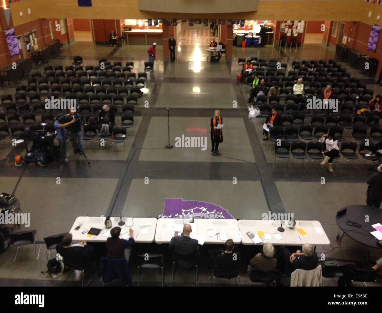 The image features a budget discussion taking place at a town hall ...
