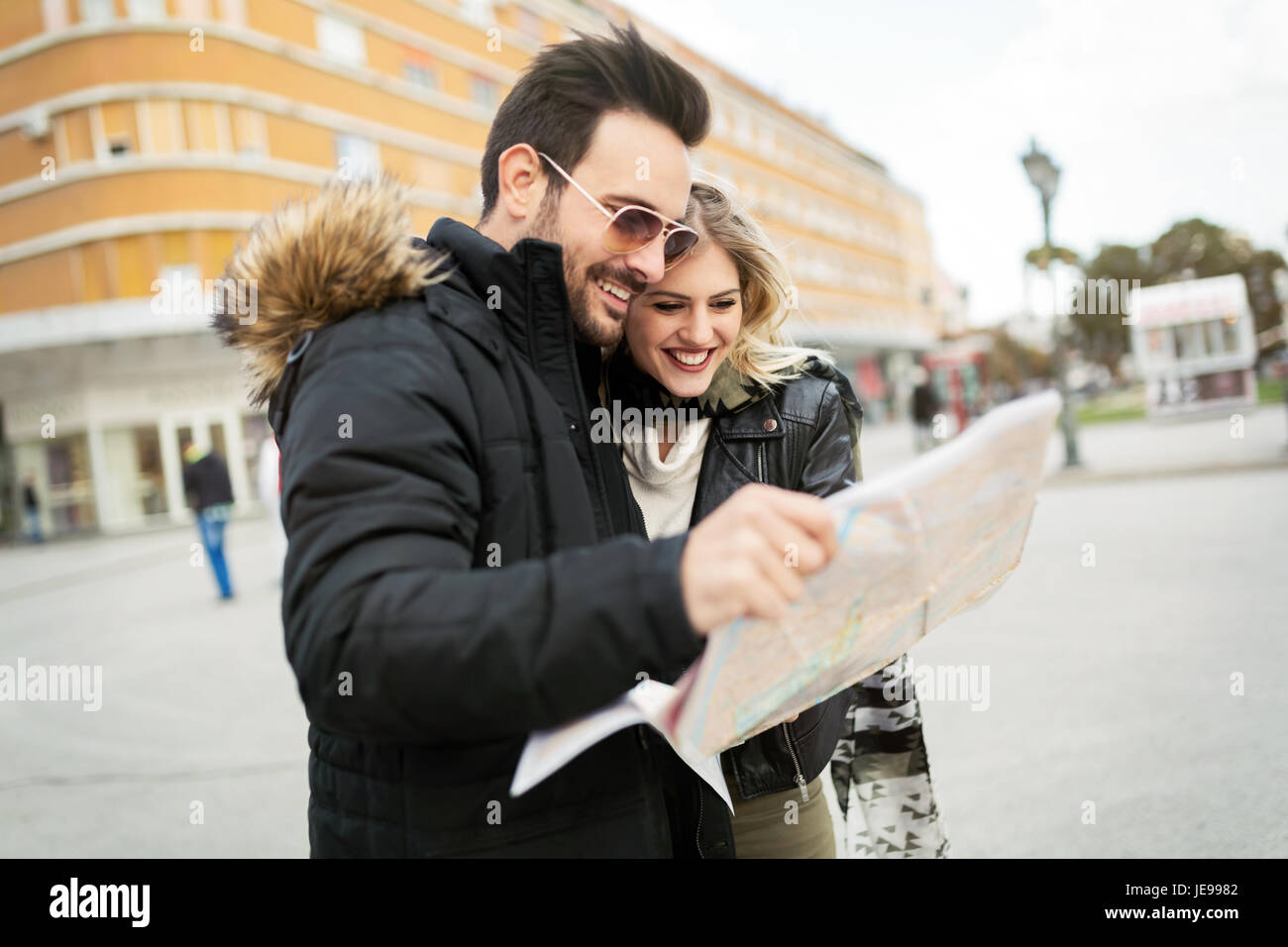 Smiling young attractive couple looking at map Stock Photo - Alamy