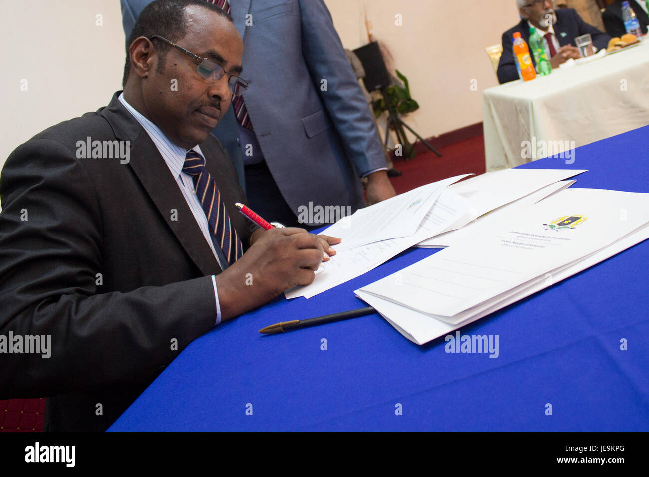 The image captures a ceremonial signing event in the South West Region ...