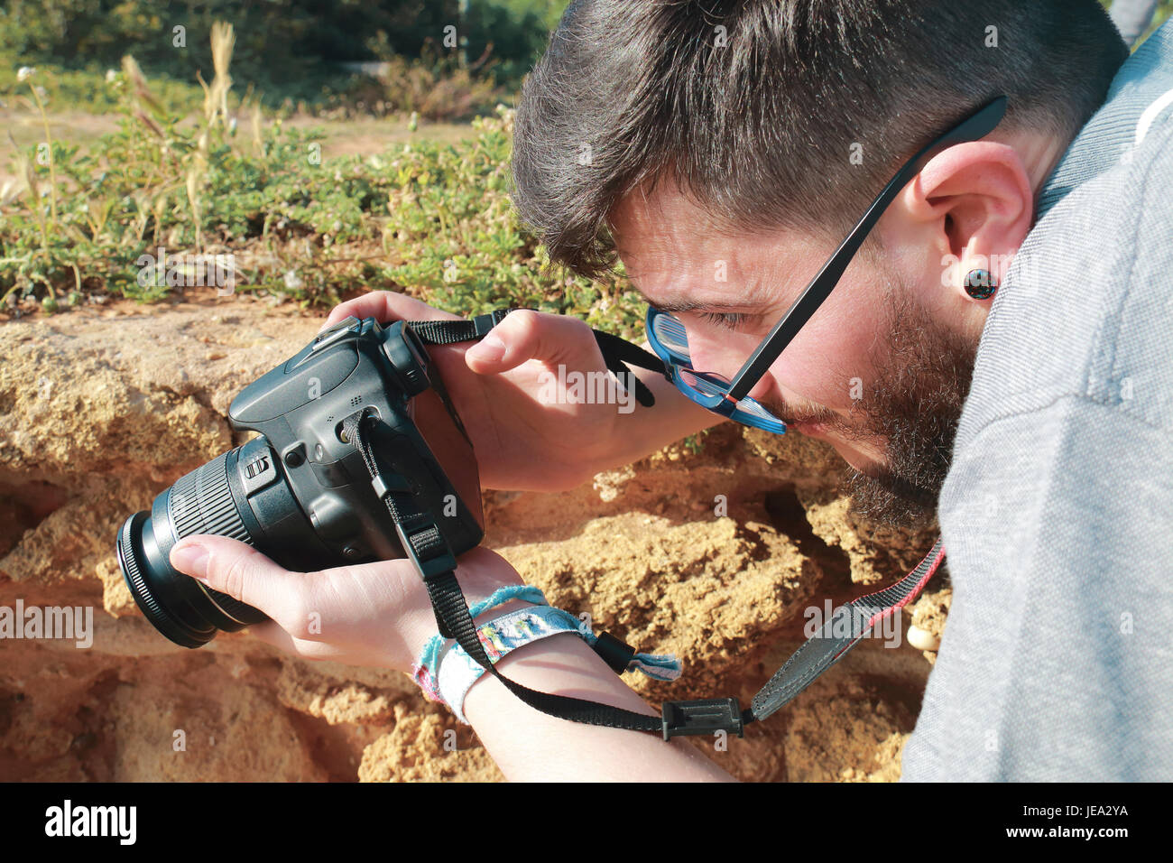 Young photographer looking at the screen of his camera Stock Photo - Alamy