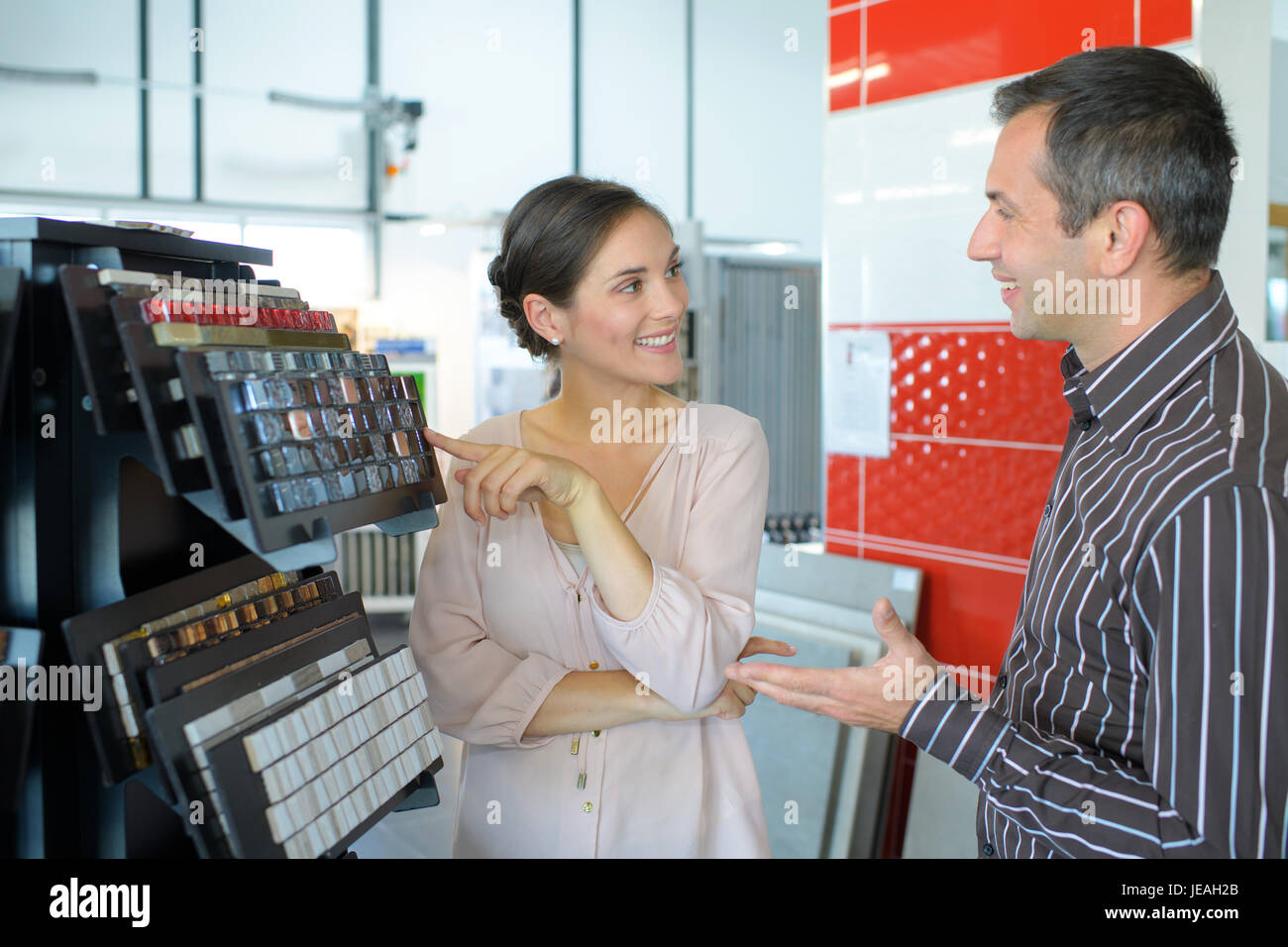 shop assistant helps customer to choose wall tiles Stock Photo - Alamy