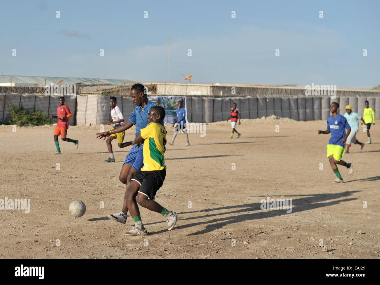 This image captures a children’s football (soccer) match at a base camp ...