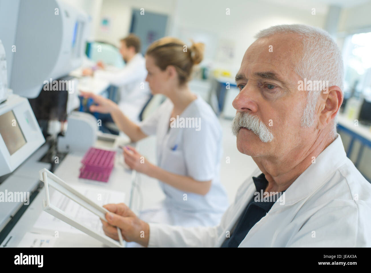 Microbiologist working on microscope in hi-res stock photography and ...