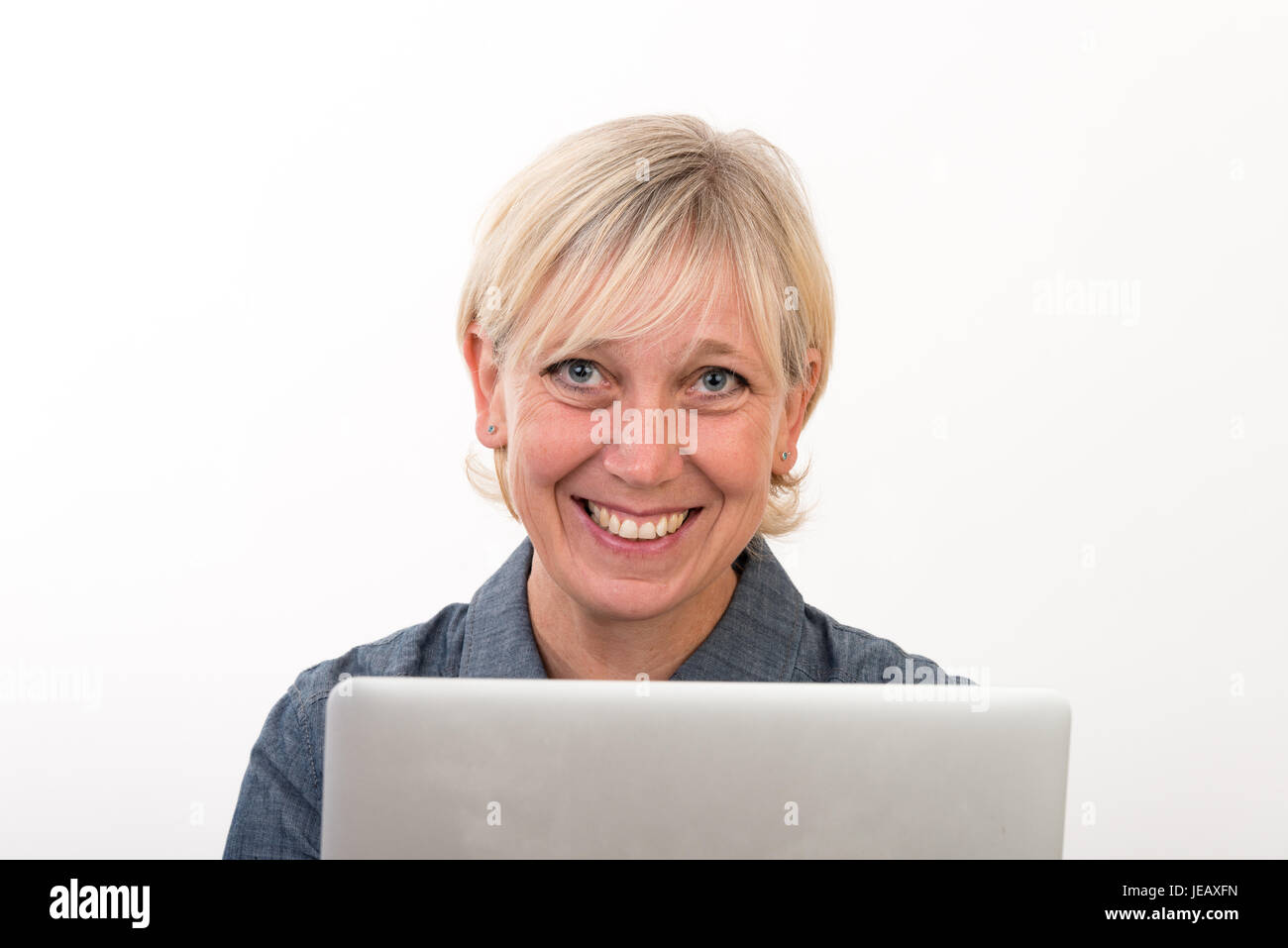 beautiful european mid aged woman working at a laptop - studio shot in ...