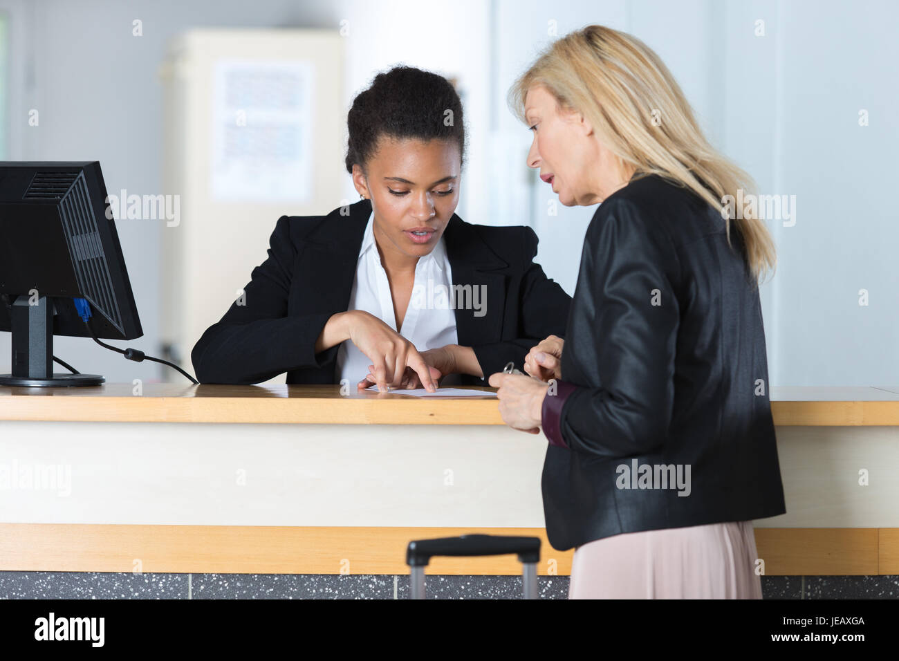 beautiful girl at the reception of a hotel checking in Stock Photo - Alamy