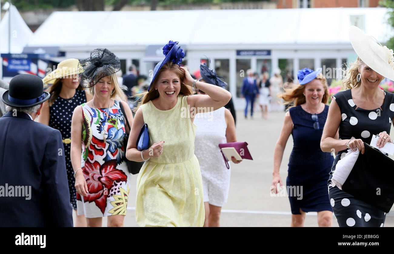 A racegoer holds on to her hat in the windy conditions during day four ...