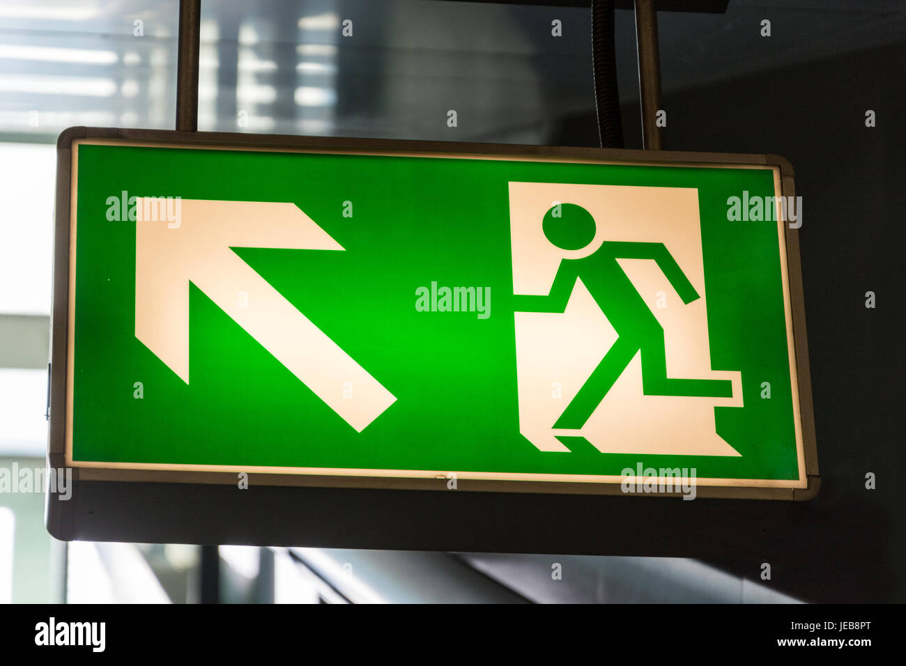 A green lighted emergency exit sign close up Stock Photo - Alamy
