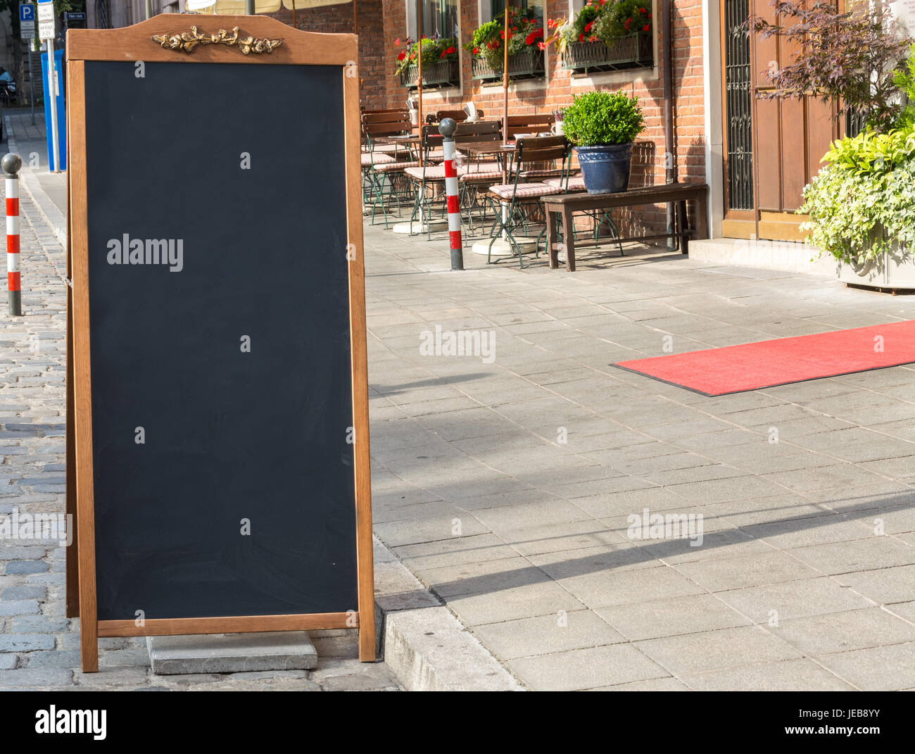 A black chalkboard stand on wood for a restaurant menu in the street ...
