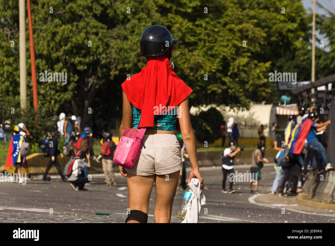 A young girl demonstrator watch a group of protester clashing with ...