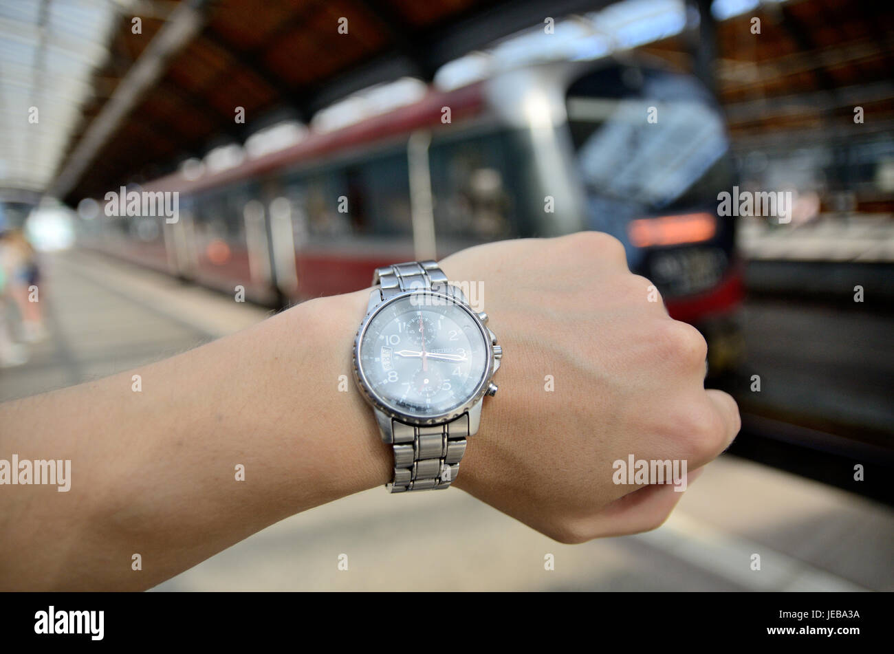 Railway station in Poland. Hand with watch, checking time and train in ...