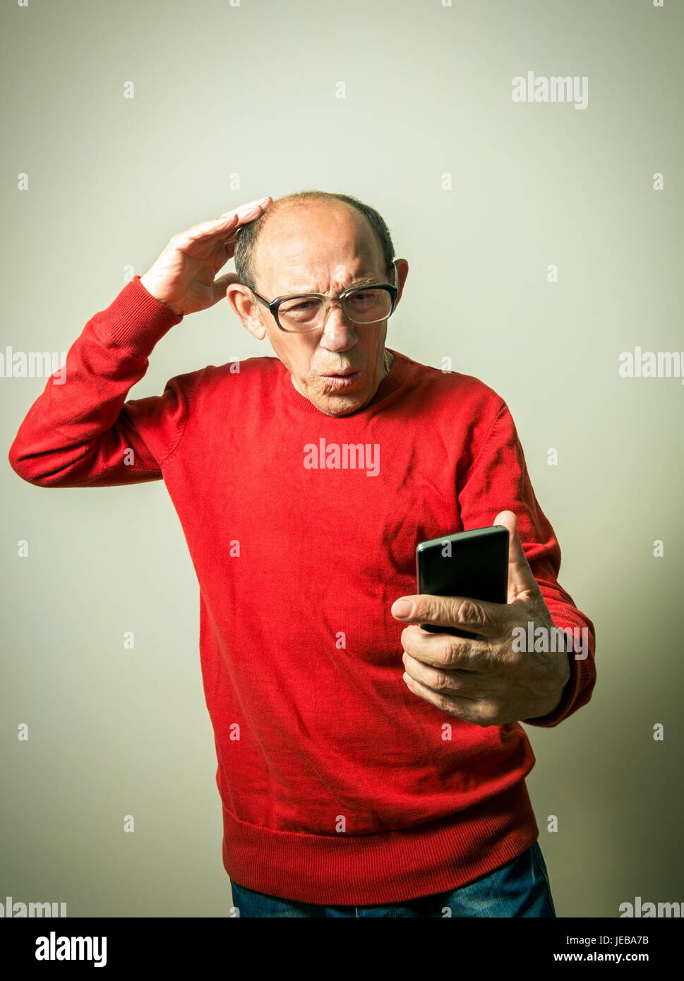 portrait of the funny senior man looking on phone Stock Photo - Alamy