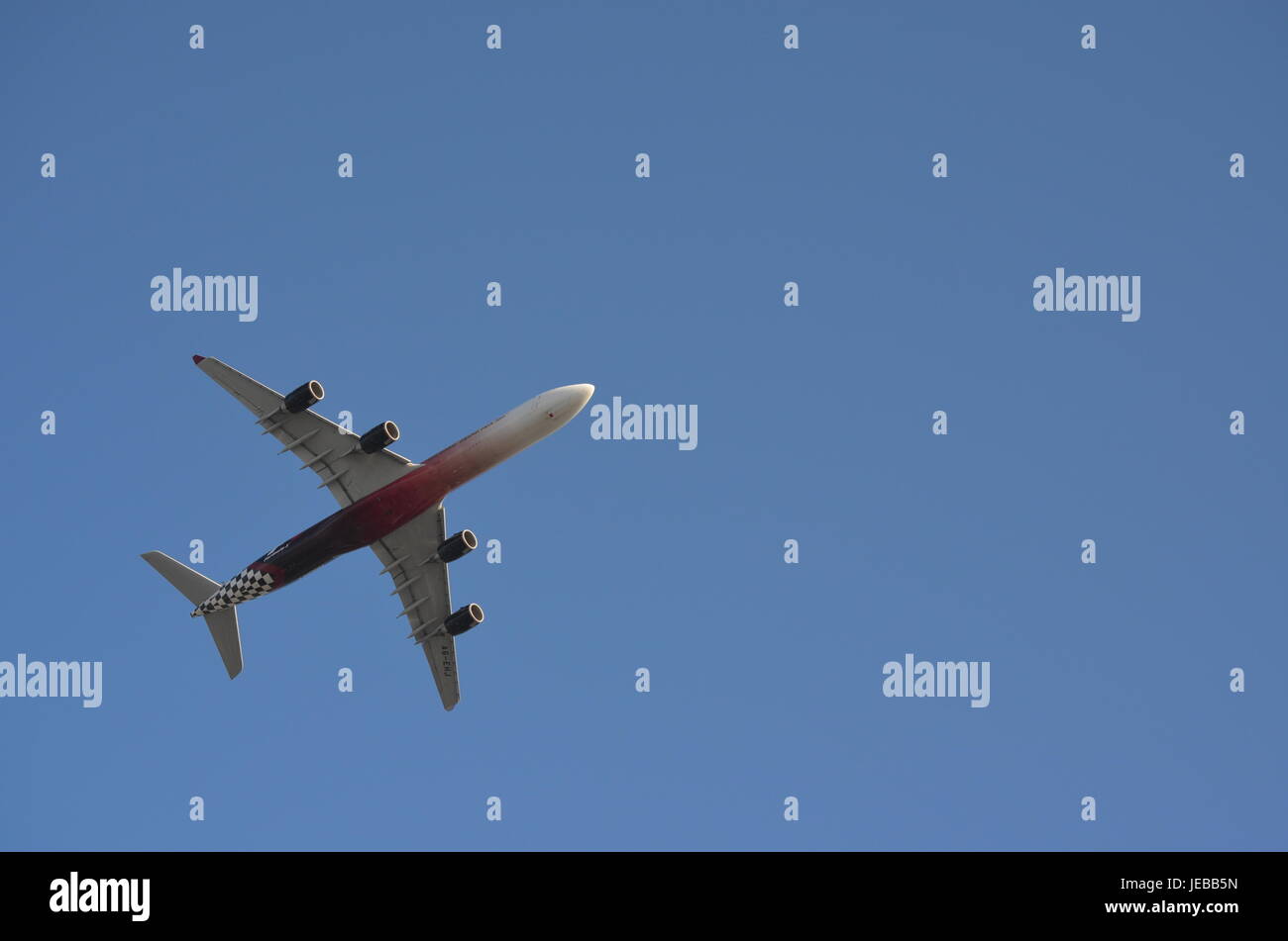 White and Dark Red Four Turbine Aircraft flying Upwards Stock Photo - Alamy