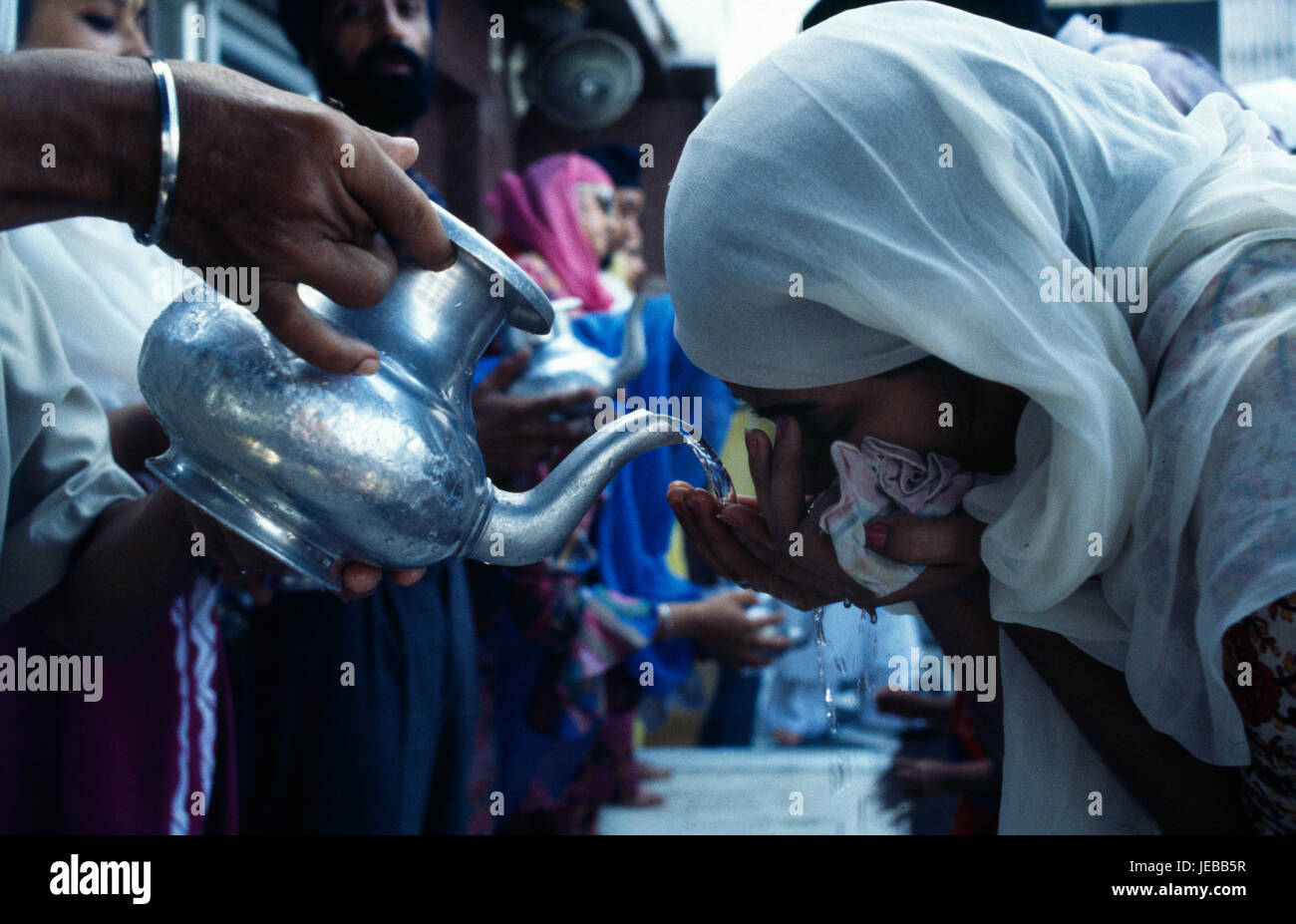India, Delhi, Pouring water for Sikh pilgrims to wash at temple Stock ...
