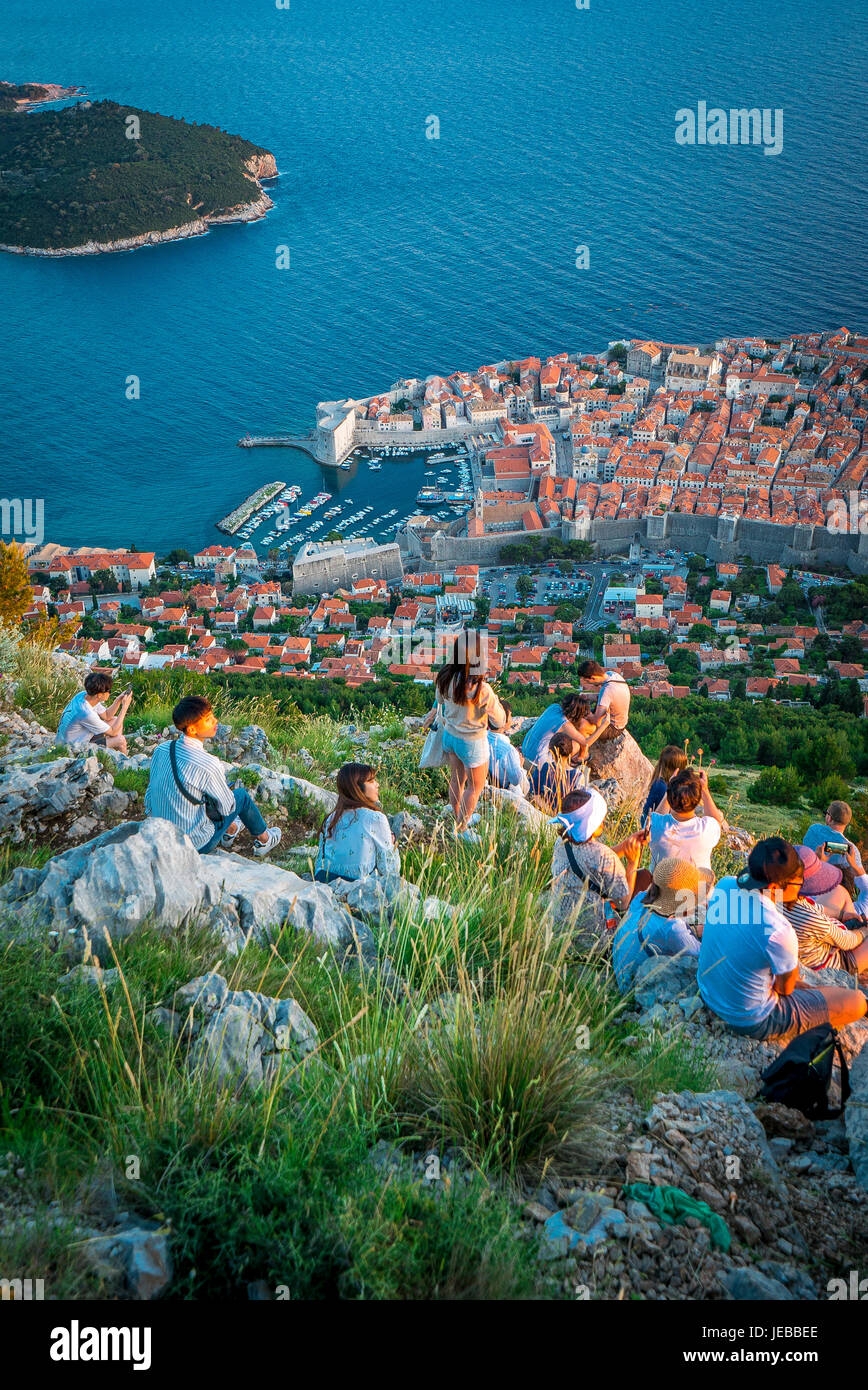 Tourists watch the sunset over the Adriatic Sea from the top of Mount ...
